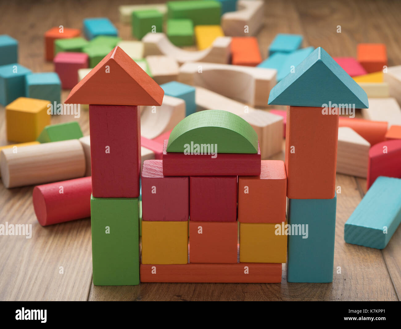 Colorful building bolcks on wooden plank Stock Photo - Alamy