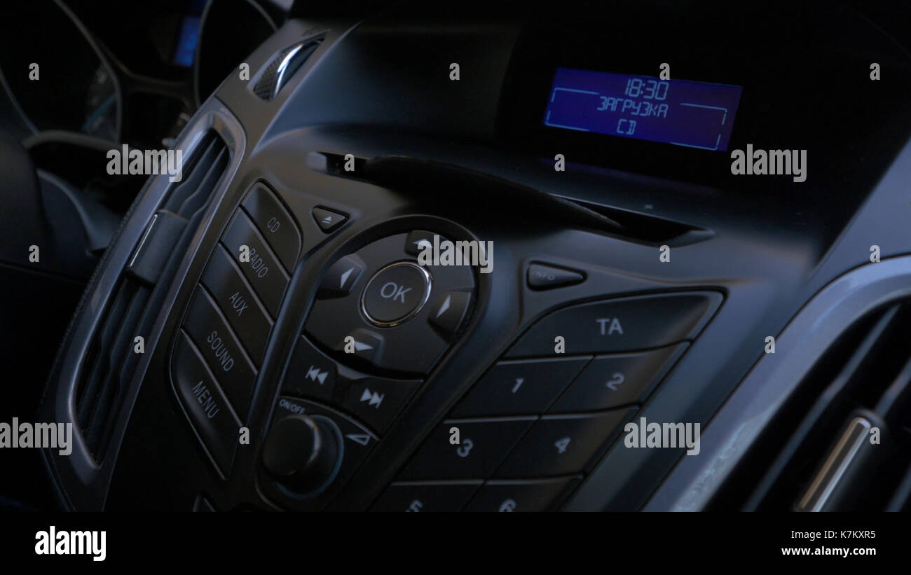 Man's hand puts the disk into the car player. Button control for ...