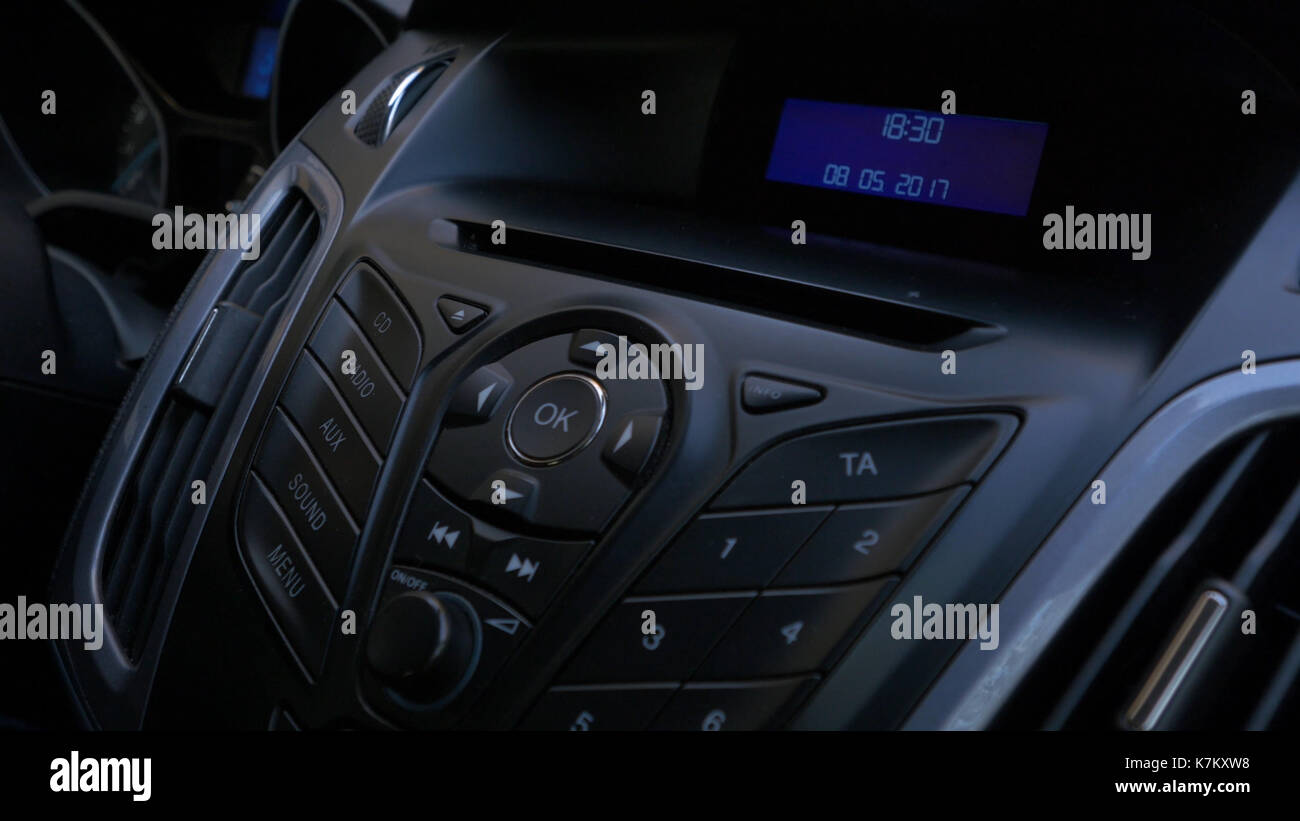 Man's hand puts the disk into the car player. Button control for ...