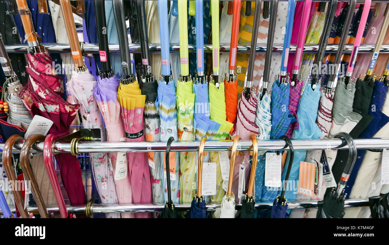 Multi colored umbrellas with metal and wooden handles in store rack ...