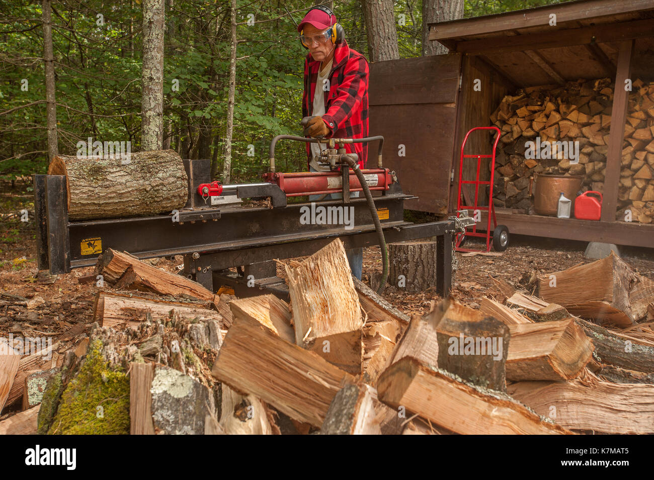 Older man using a log splitter Stock Photo - Alamy