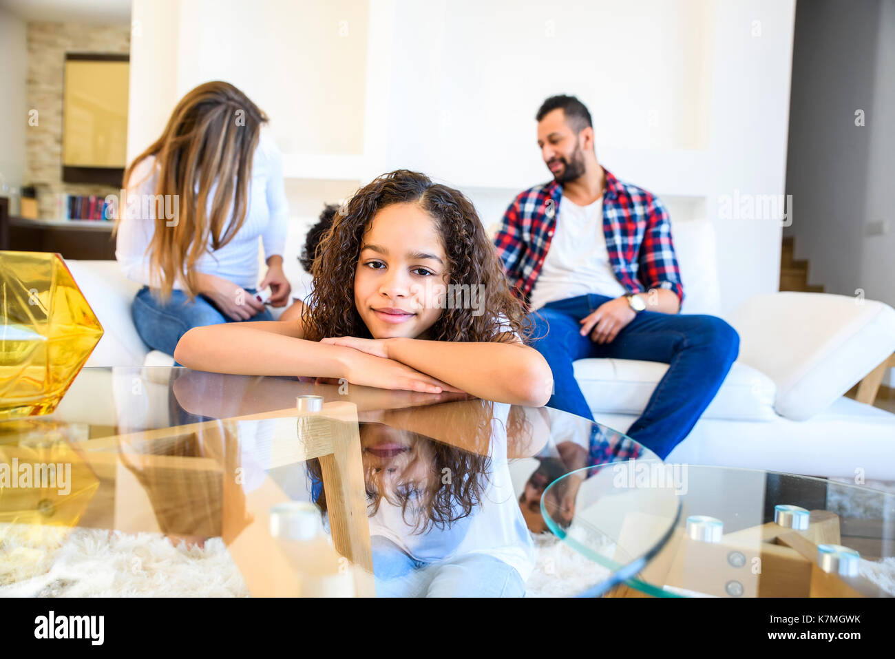 Portrait of a young teenage african girl leaning on a coffee table ...