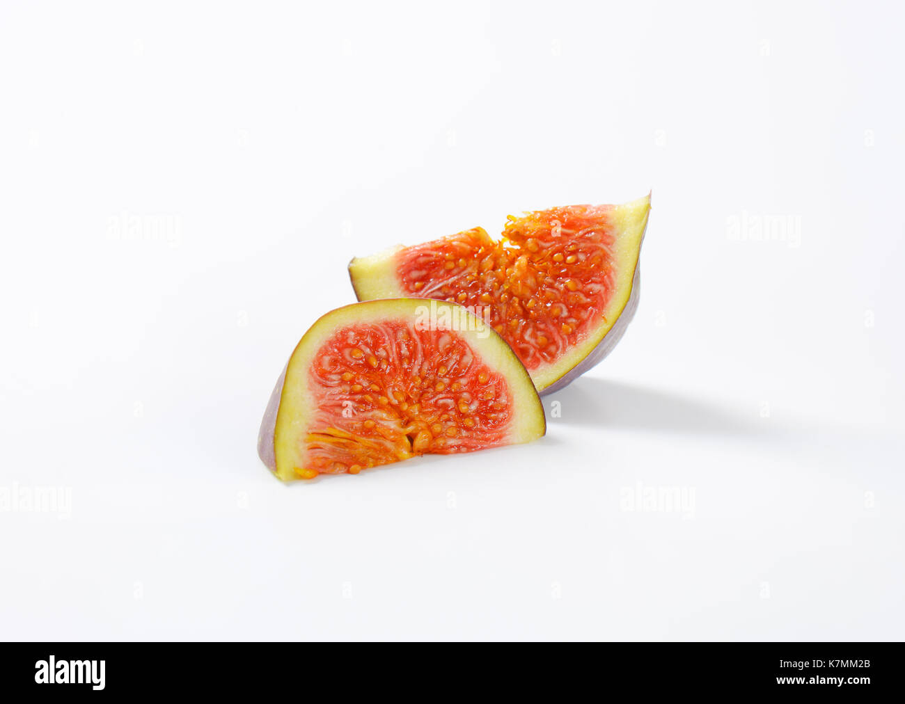 two slices of ripe fig on white background Stock Photo - Alamy