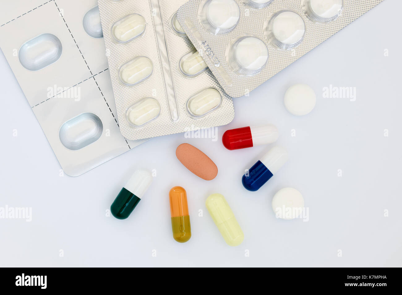 Colored capsules, pills medicines and blister photographed on a white ...