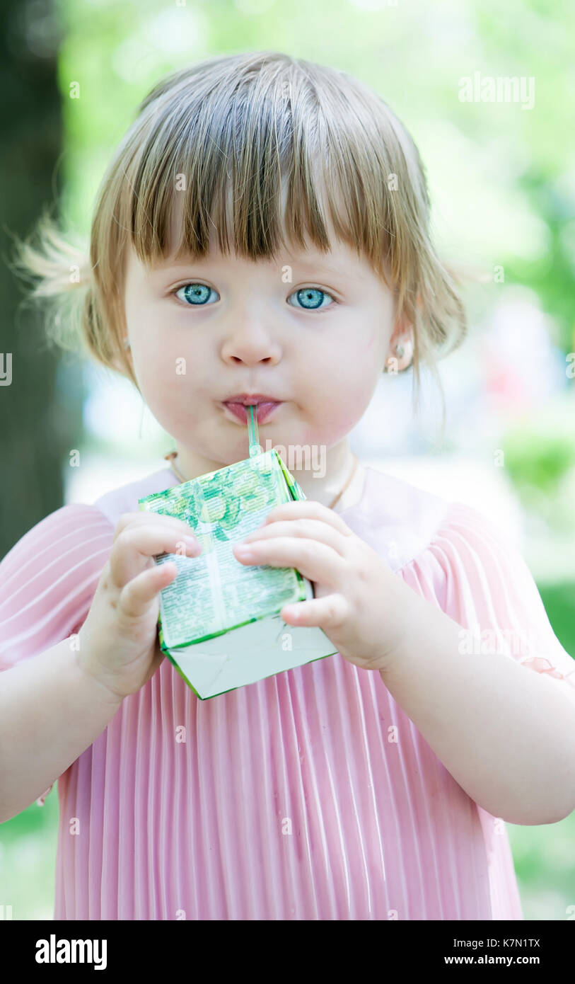 little lovely girl drinking juice Stock Photo - Alamy