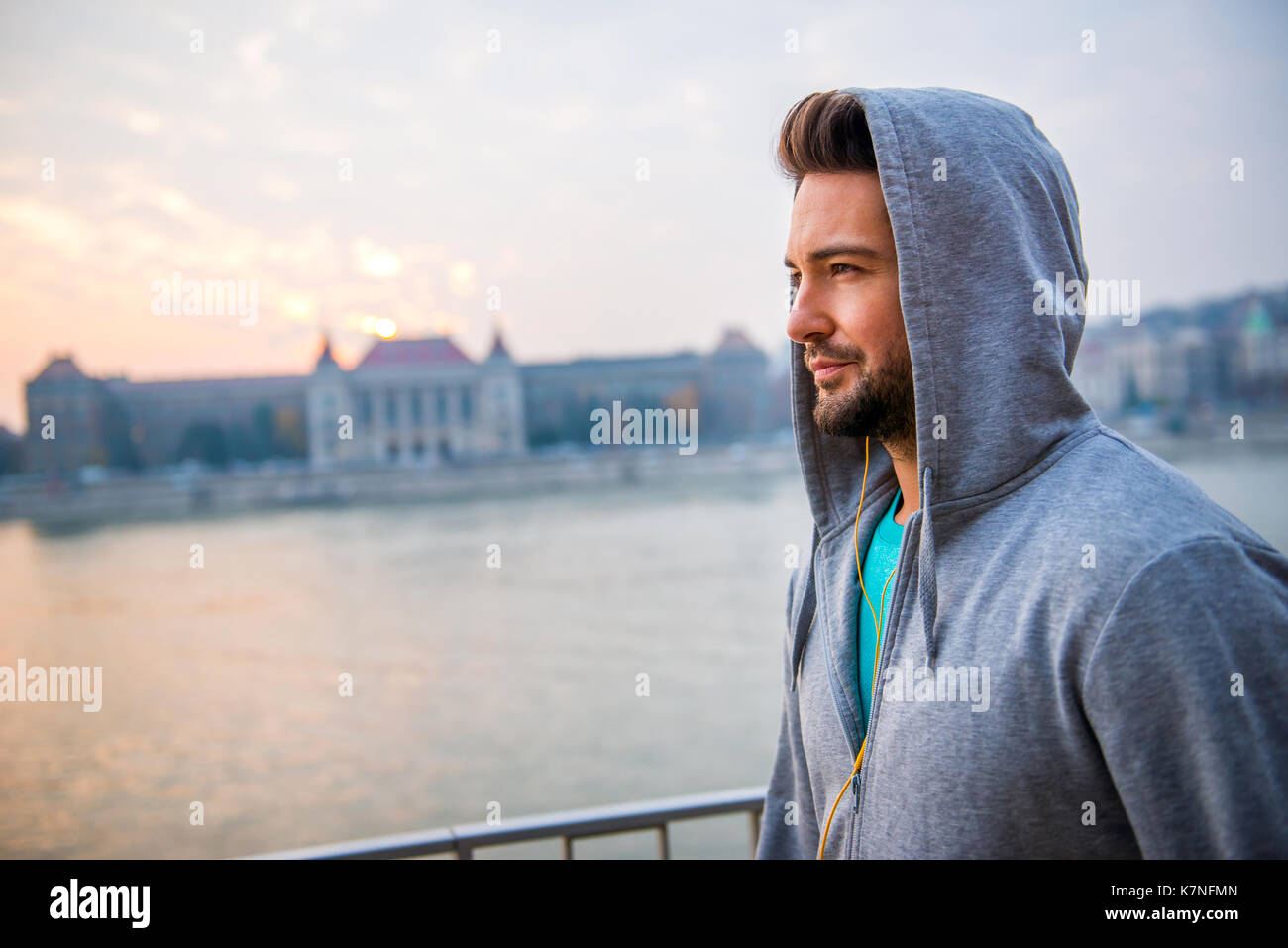A handsome young man running at the riverside in the sunset Stock Photo ...