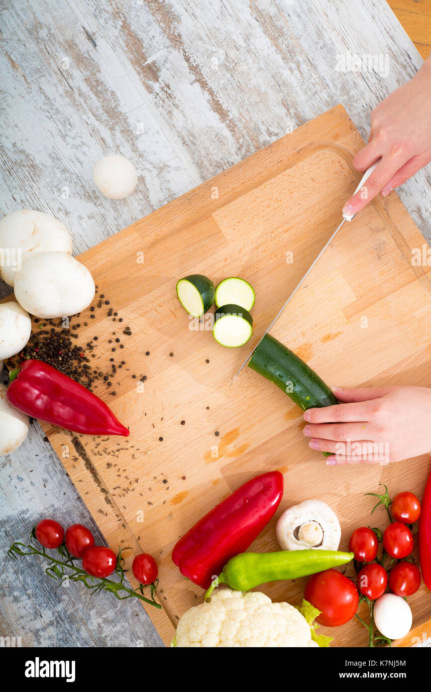 A woman chopping up vegetables at a table Stock Photo - Alamy