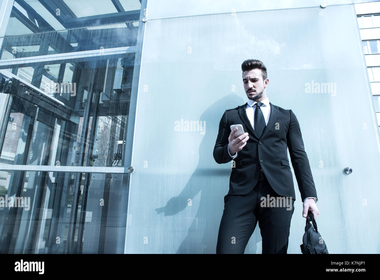 A business man standing in front of a modern office building Stock ...