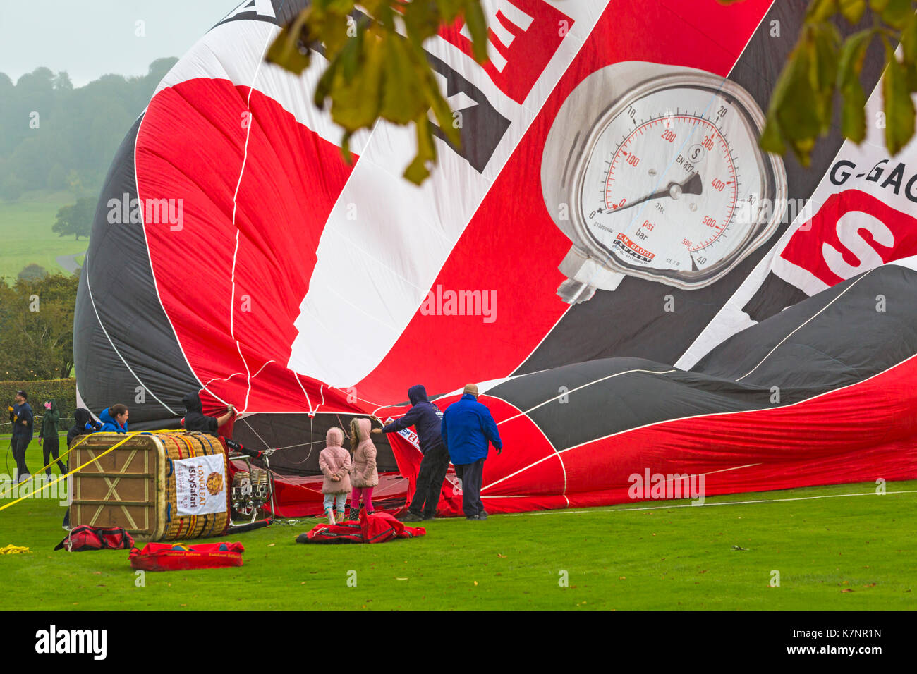 People around basket of hot air balloon on ground being inflated at Sky ...