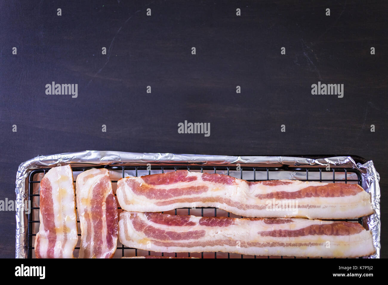 Raw bacon strips with fresh spices on a baking sheet Stock Photo - Alamy