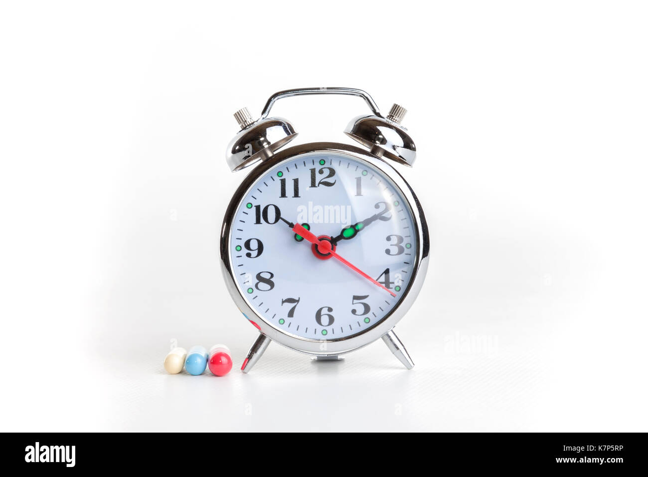 Medicines and alarm clock on white background Stock Photo - Alamy