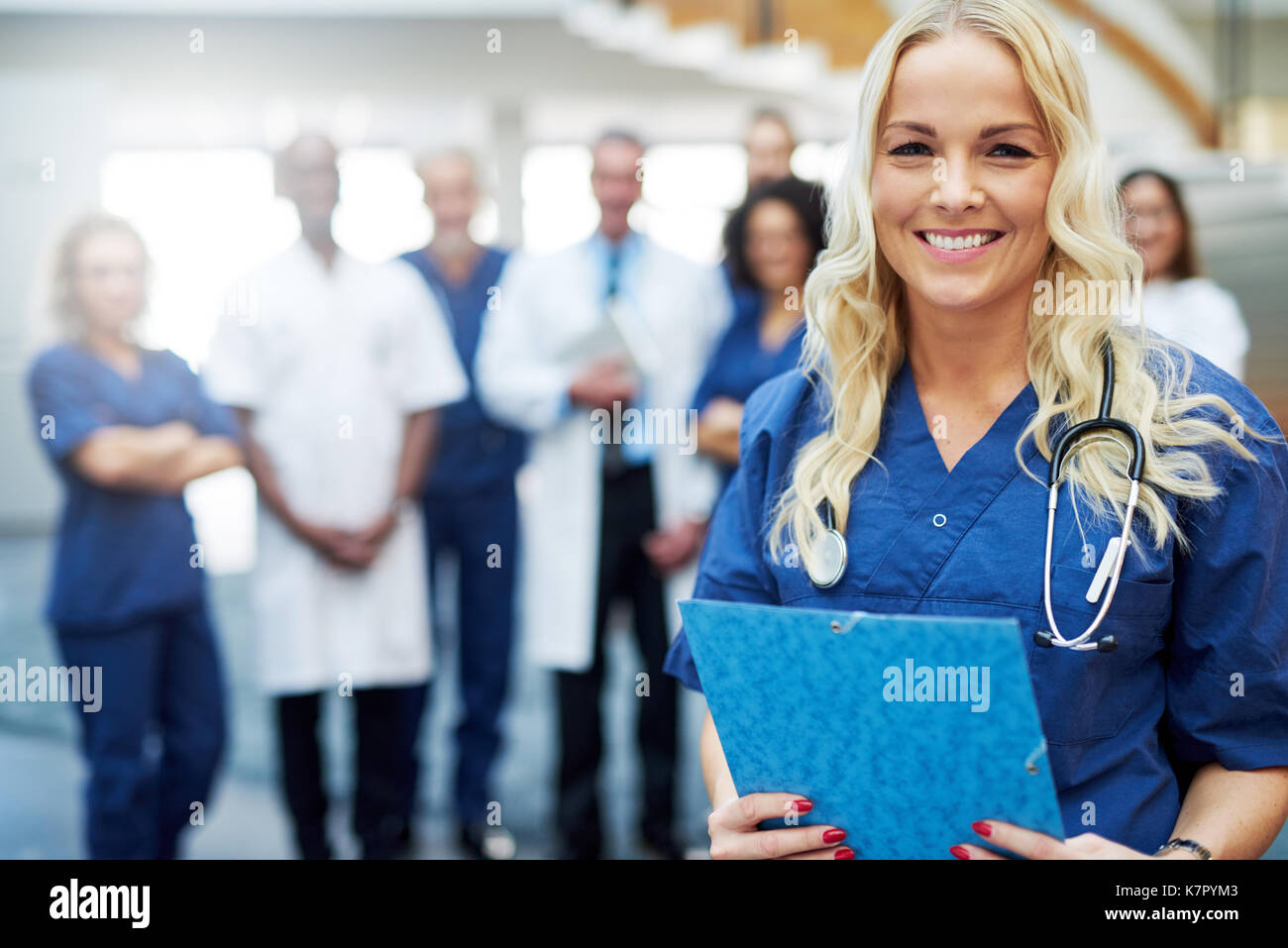 Female medical professional standing in a clinic and looking at camera ...