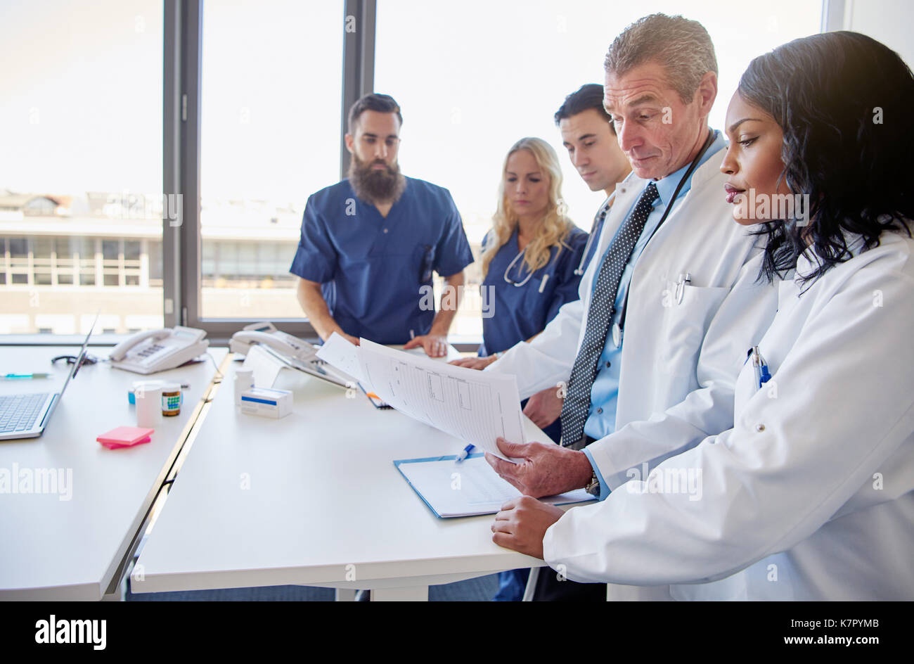Team of doctors talking and looking at papers in the clinic. Multi ...