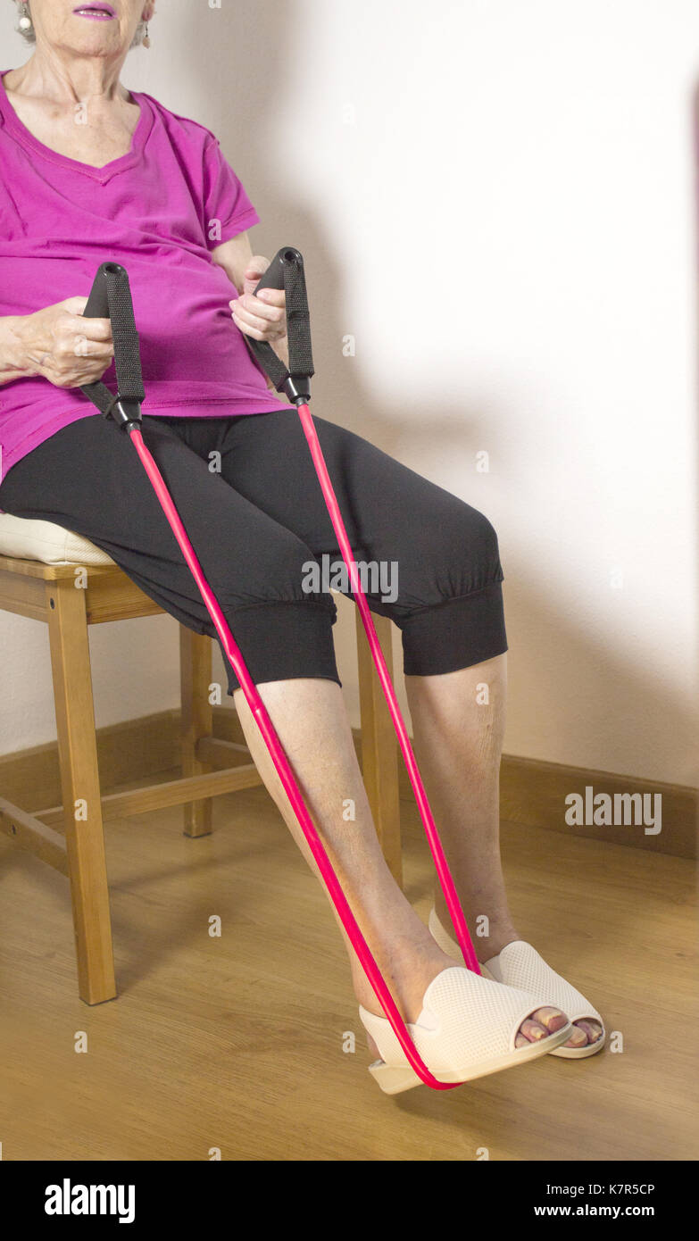 Rehabilitation exercises with elastic resistance rubber for older woman ...
