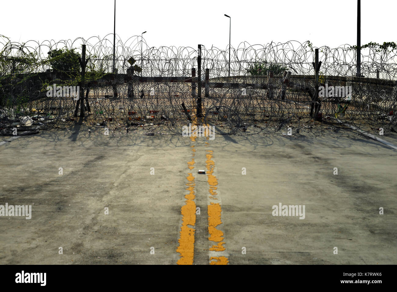 barbed tape or razor wire cross the road Stock Photo - Alamy