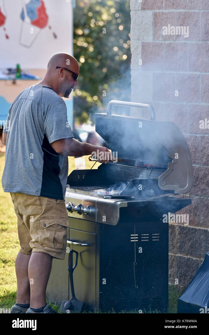 Man using BBQ to grill for barbecue food at concession stands Stock ...