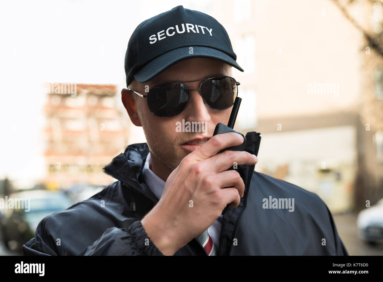 Portrait Of Young Male Security Guard Talking On Walkie-talkie Stock ...