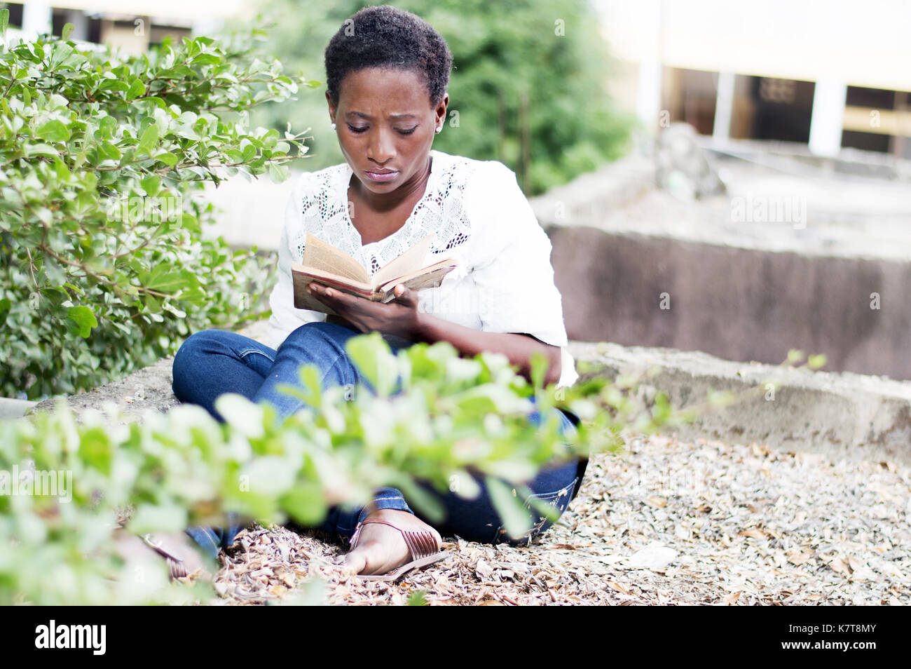 young woman sitting with crossed legs and reading a book Stock Photo ...
