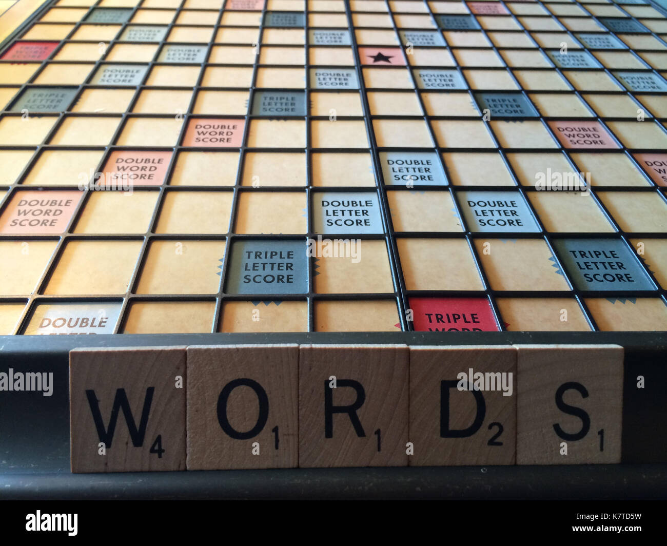 The word "words" on game tiles next to a Scrabble game board Stock ...