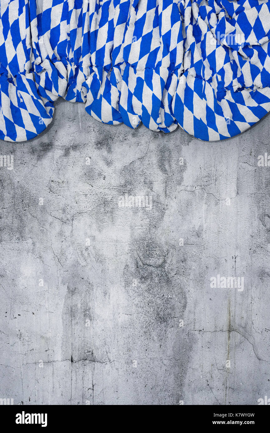 folded flag with bavarian colors of white and blue on empty concrete ...