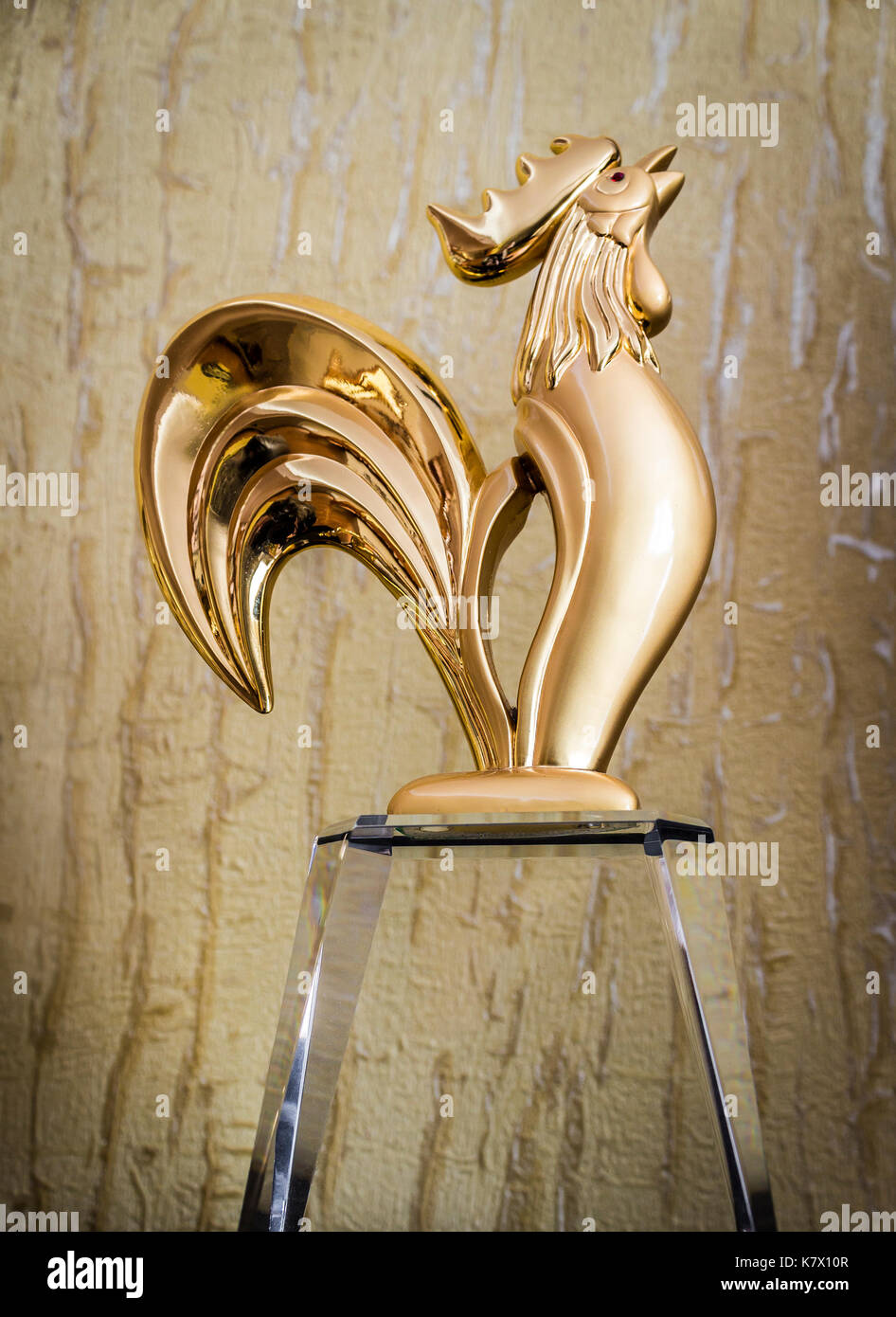 Golden rooster figurine close-up on a wall background Stock Photo - Alamy