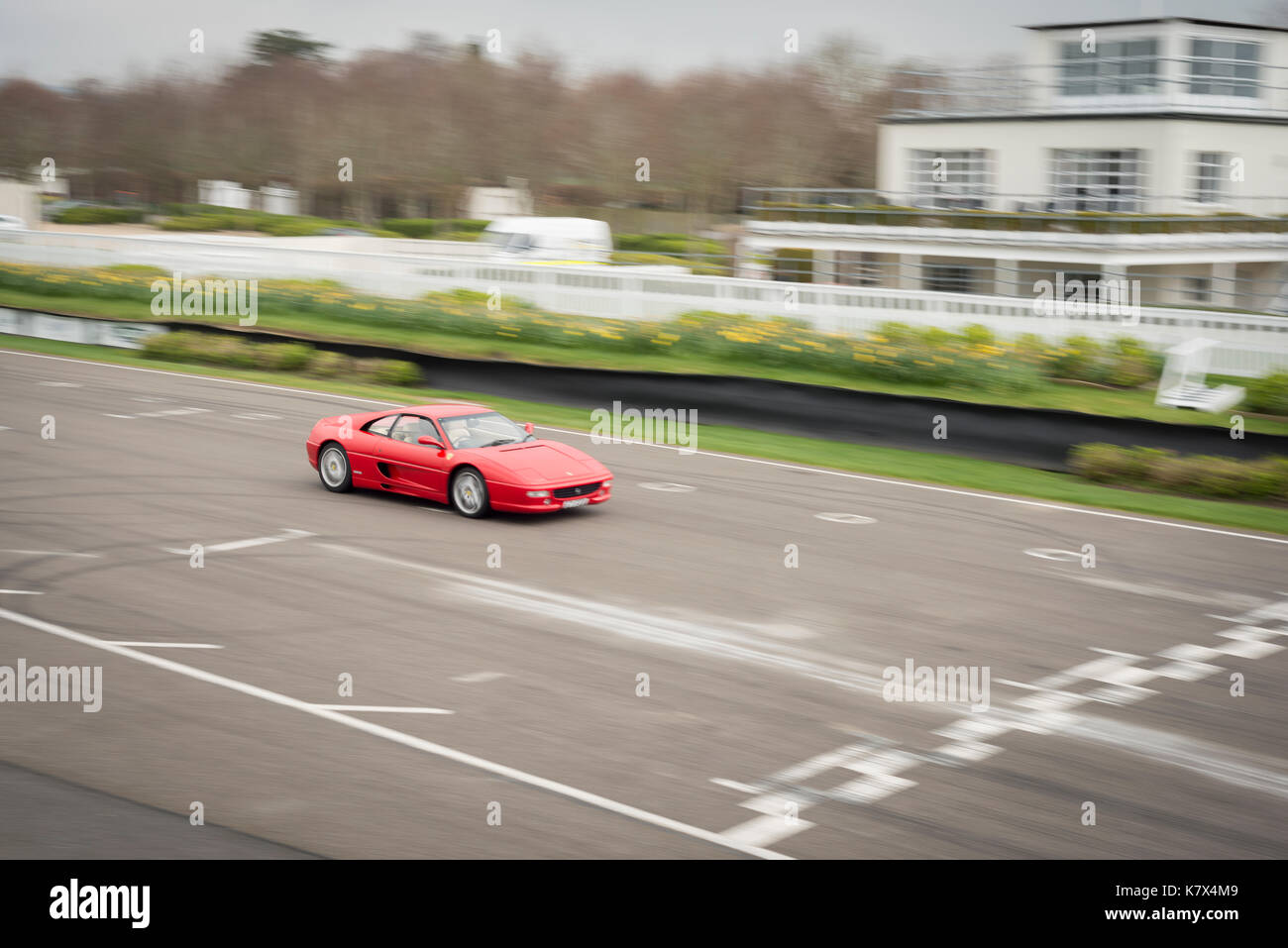 Fast red car on racetrack at Goodwood Stock Photo - Alamy