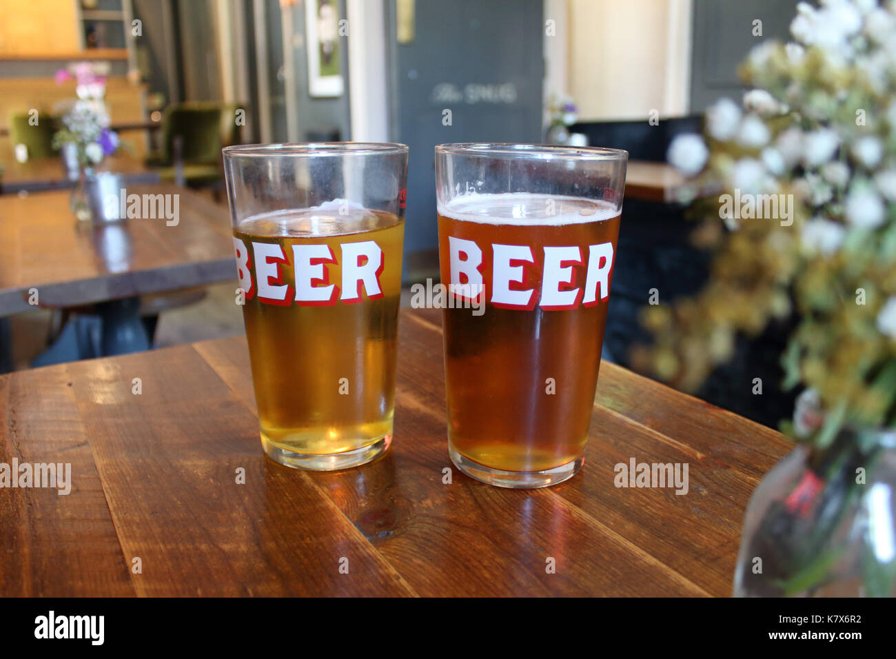 Two pints in "BEER" glasses in a pub. Shallow focus on glasses. London ...