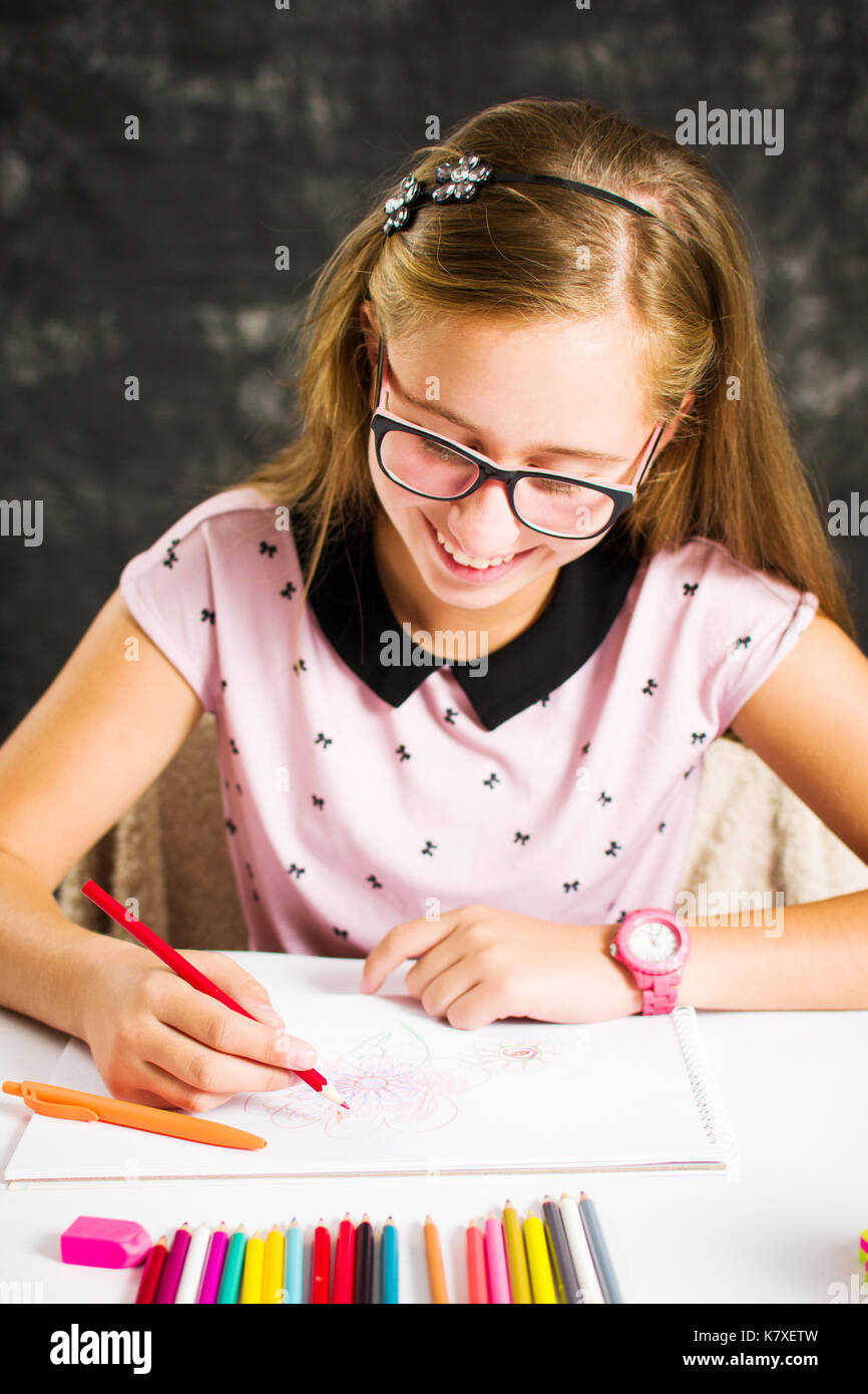 Happy girl drawing a flower with colorful pencils Stock Photo - Alamy