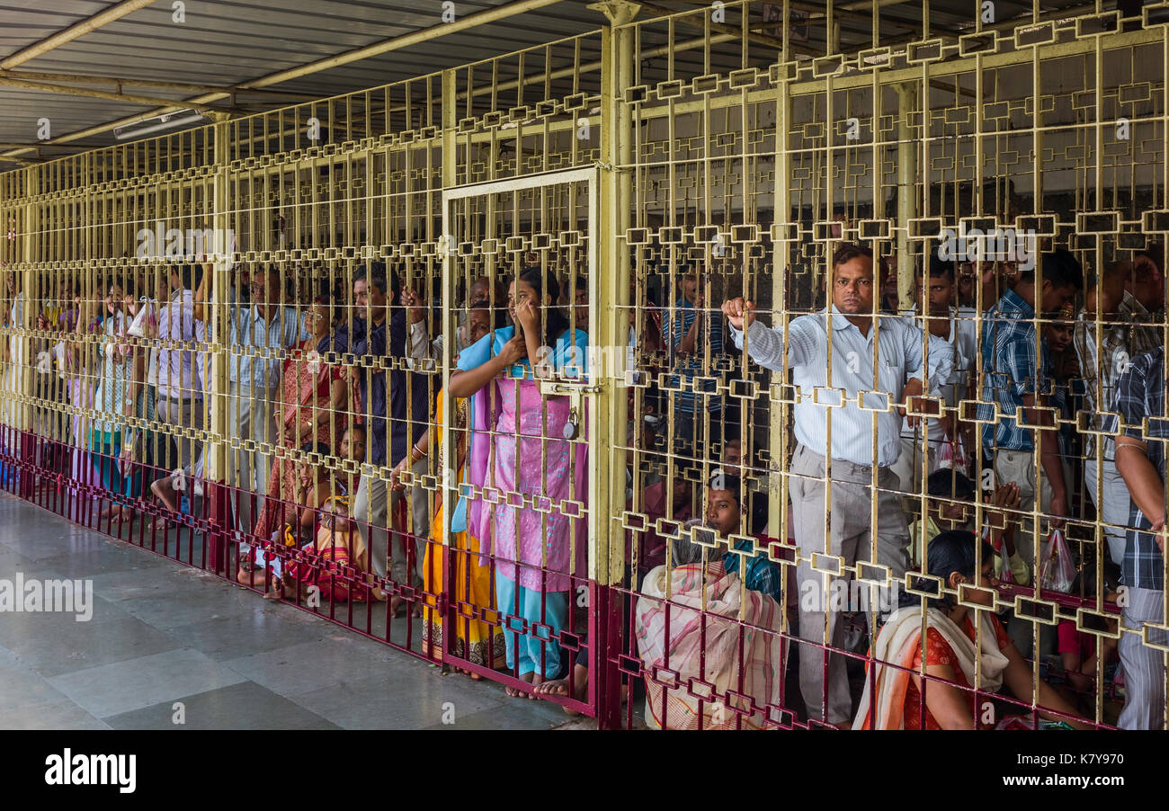 Hindu devotees corralled behind metal bars hoping to gain access to the ...