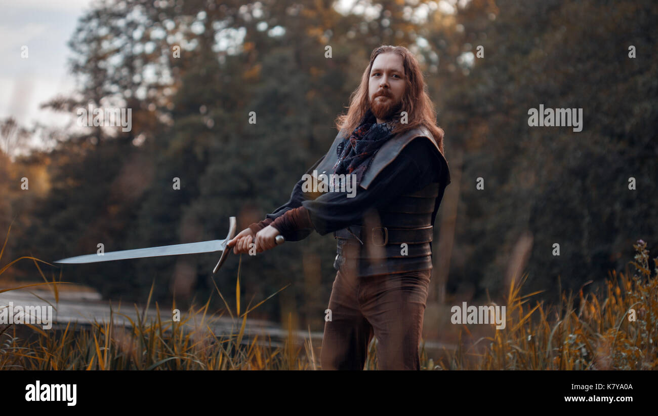The bearded man knight. A guy in a medieval costume with a sword Stock ...