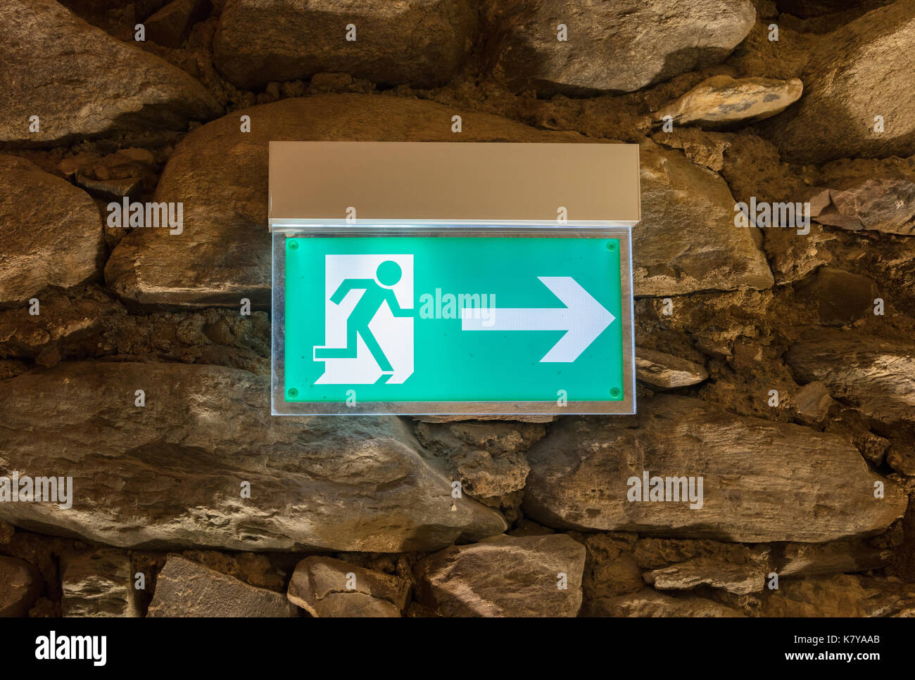 Green emergency exit sign hanging in an old building Stock Photo - Alamy