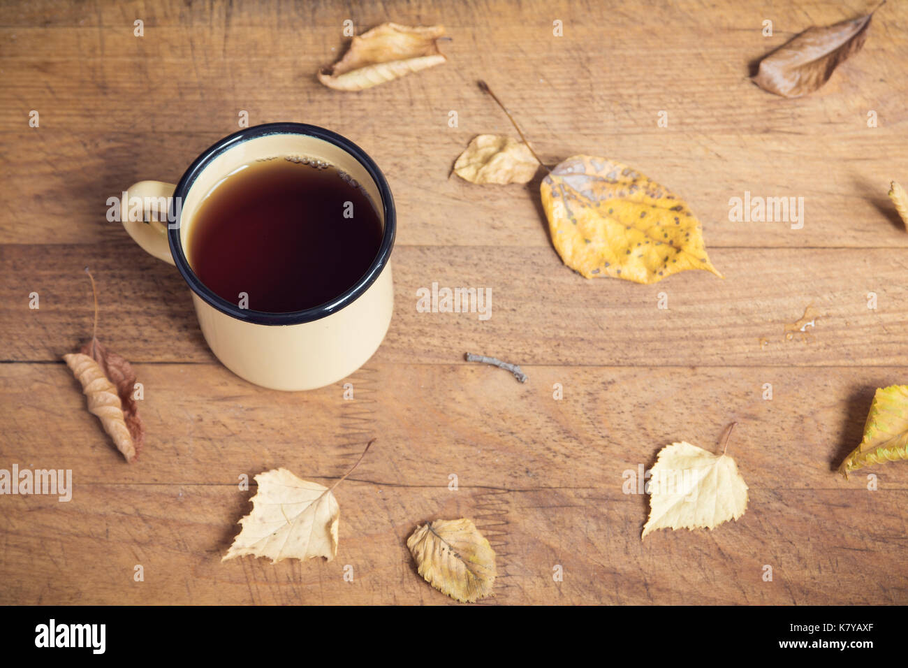 Hot autumn tea and yellow dry leaves, top view. Seasonal cozy drink in ...