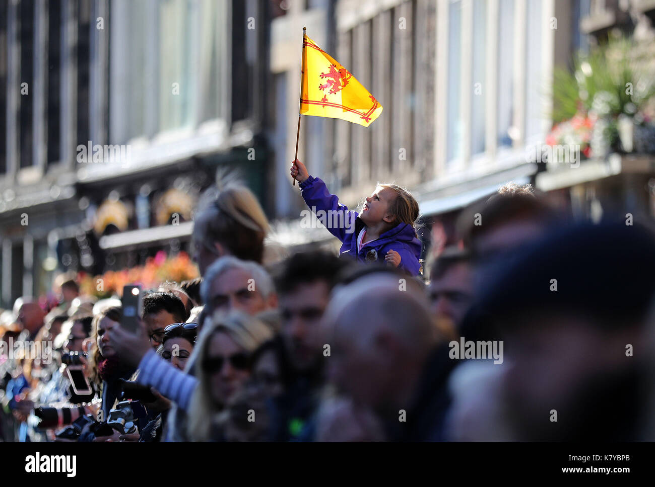 A girl in the crowd waves a Saltire flag as hundreds of horses and ...