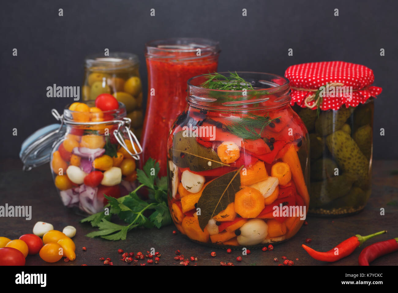 Homemade organic various preserves and ingredients on dark concrete ...