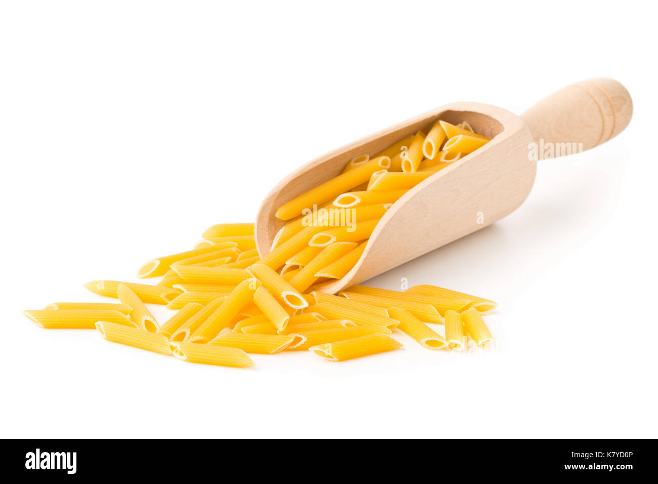 Dry, uncooked, raw penne pasta noodles in wooden scoop on white ...