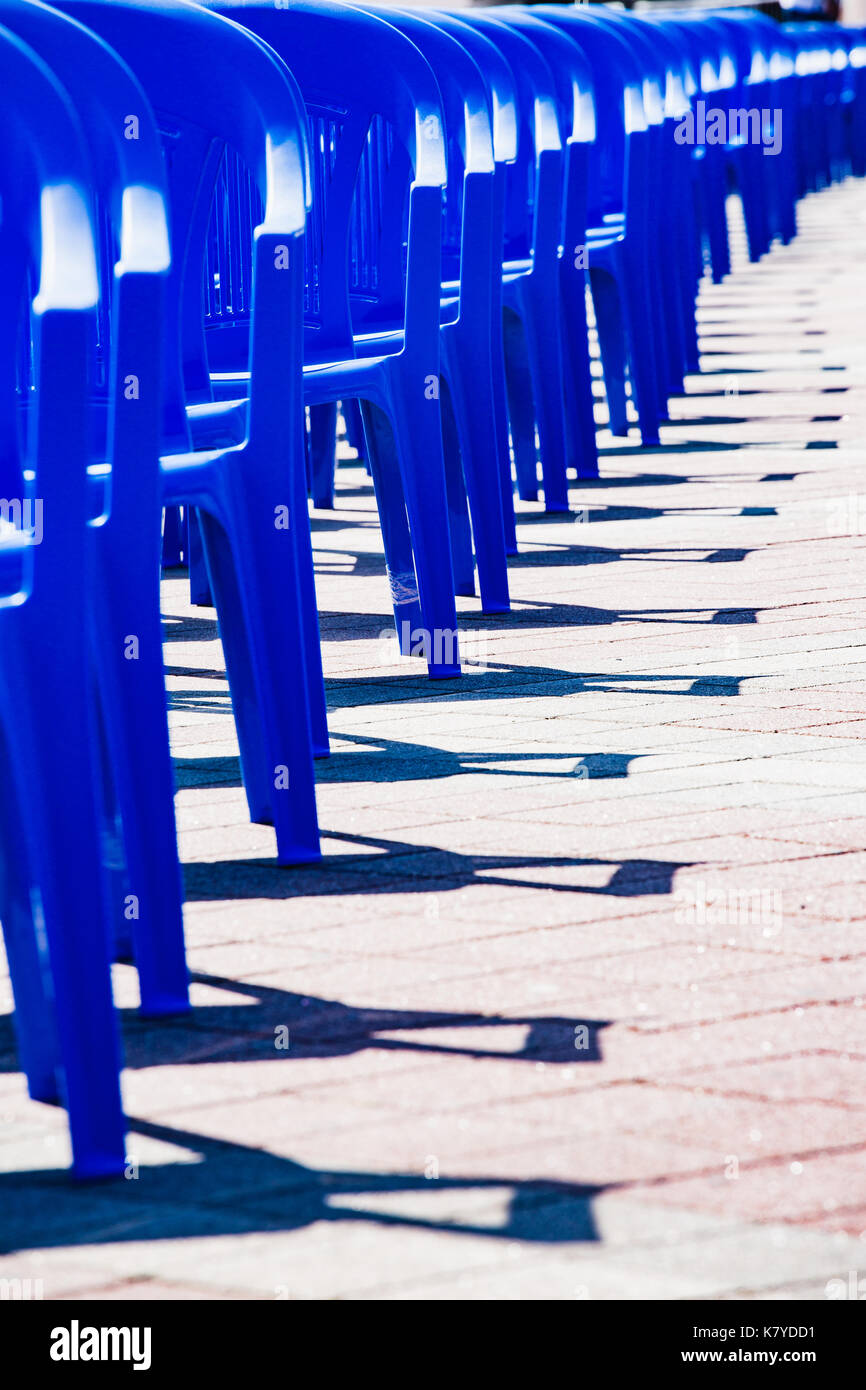 Bright plastic chairs standing in a row Stock Photo - Alamy