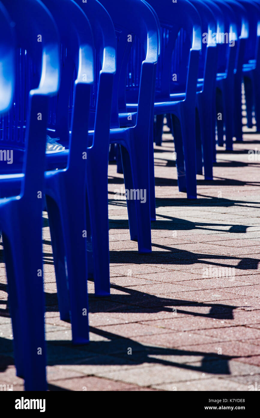 Bright plastic chairs standing in a row Stock Photo - Alamy