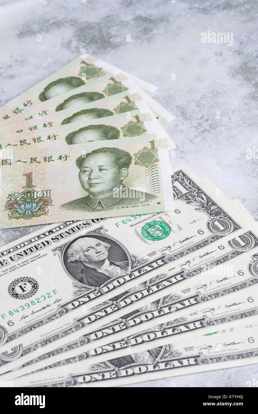 US dollar bills with Chinese Yuan / Renminbi banknotes on a printed ...