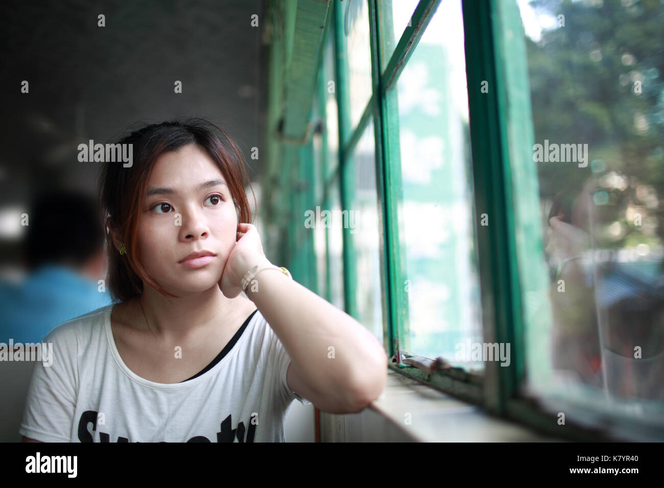 Sad woman waiting someone who is late, after cry,she look outside ...