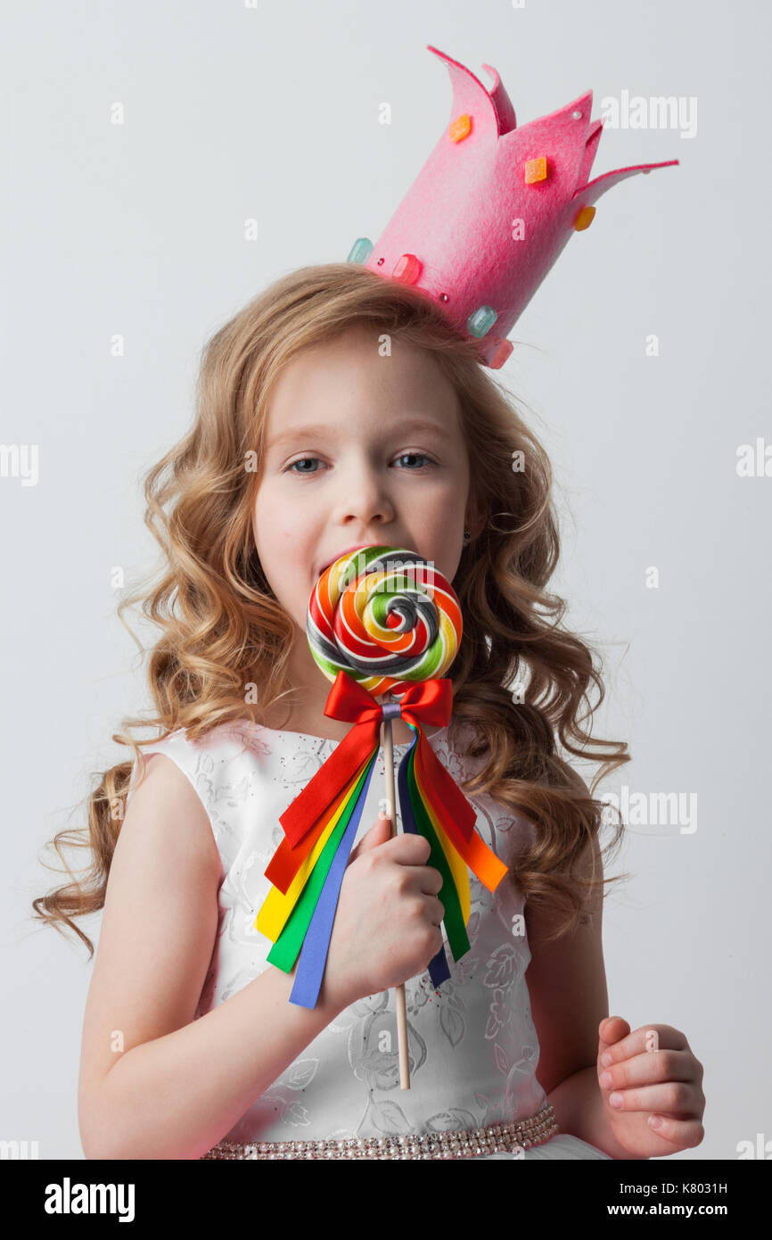 Beautiful little candy princess girl in crown holding big lollipop and ...