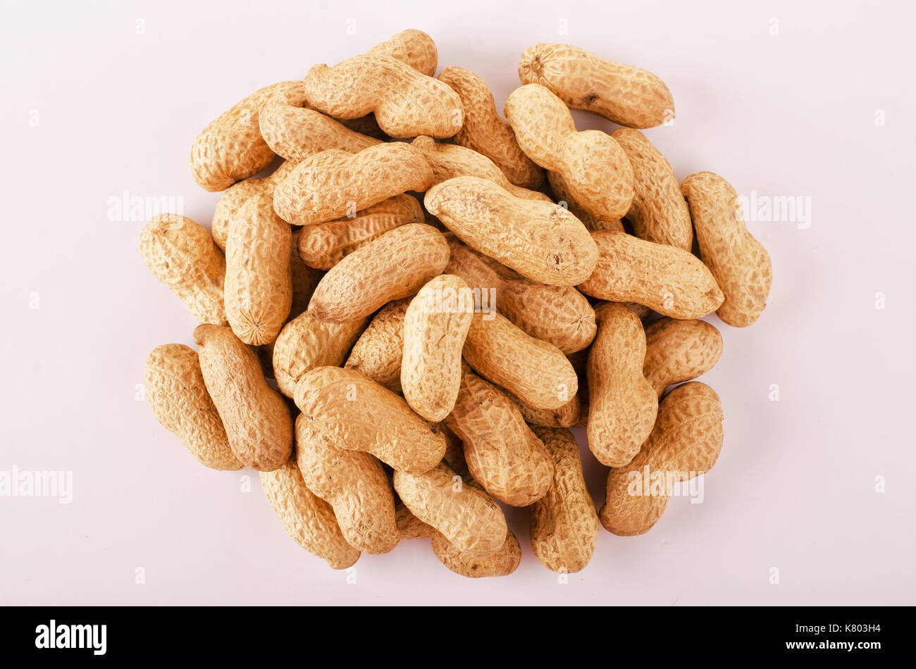 Roasted inshell peanuts scattered on a white background Stock Photo - Alamy