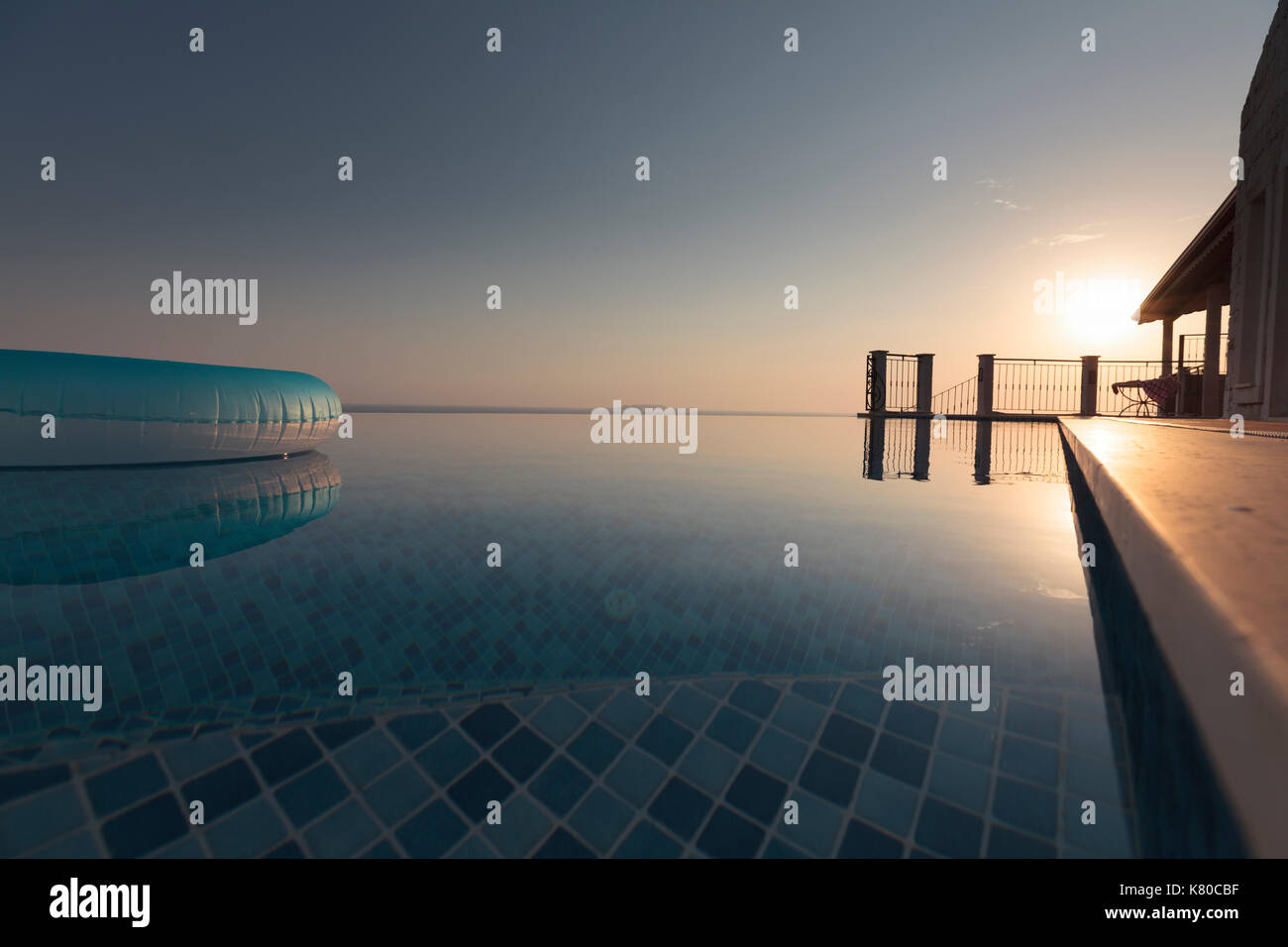 View into distance across infinity pool with lie lows and rings and sun ...