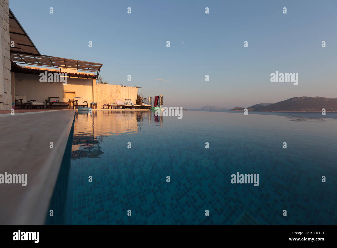 View into distance across infinity pool with lie lows and rings and sun ...