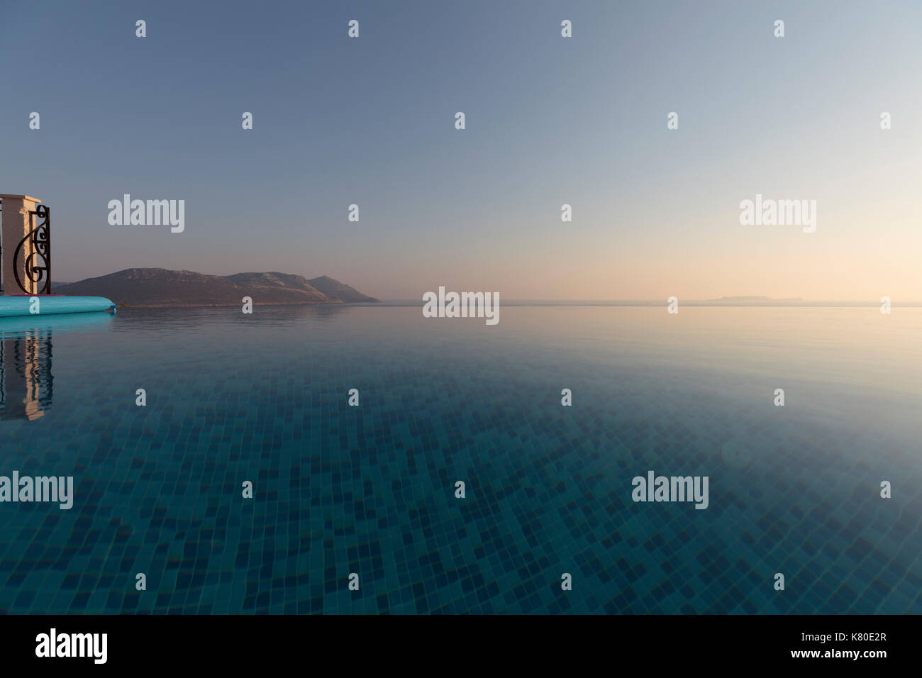 View into distance across infinity pool with lie lows and rings and sun ...