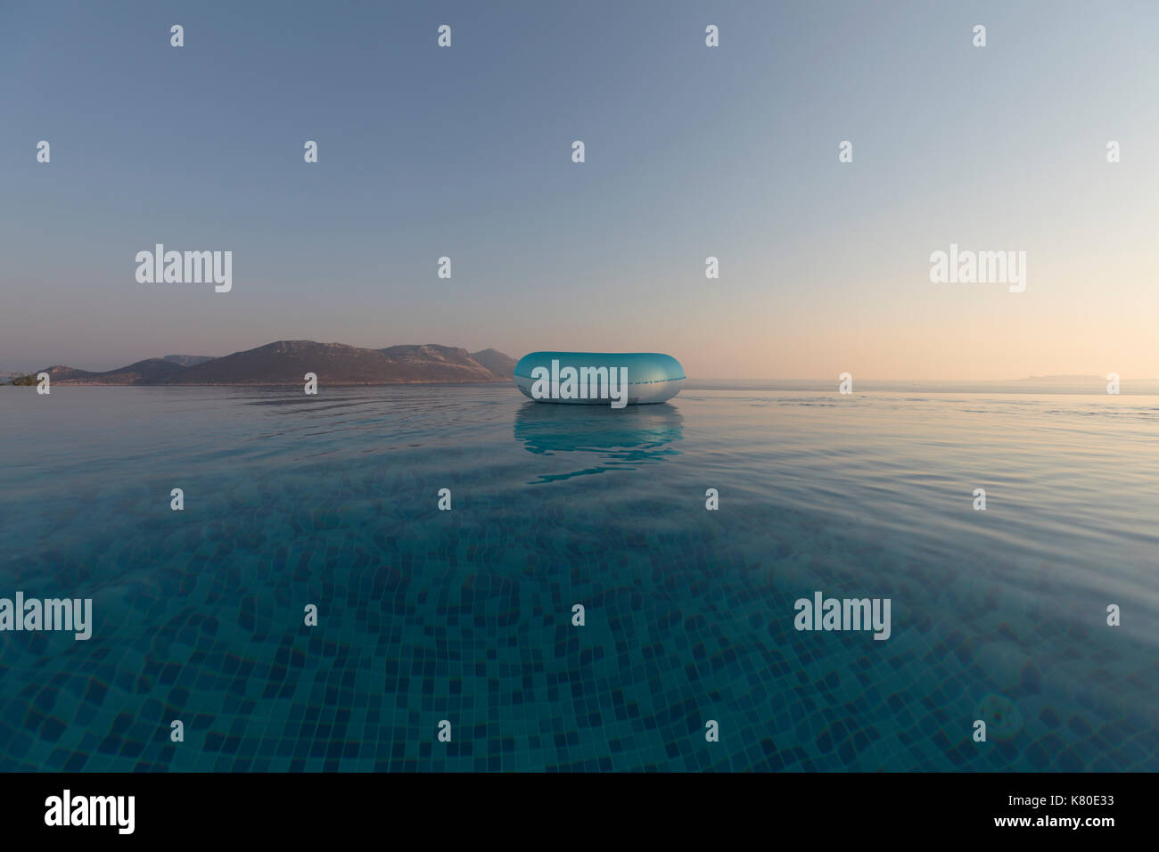 View into distance across infinity pool with lie lows and rings and sun ...