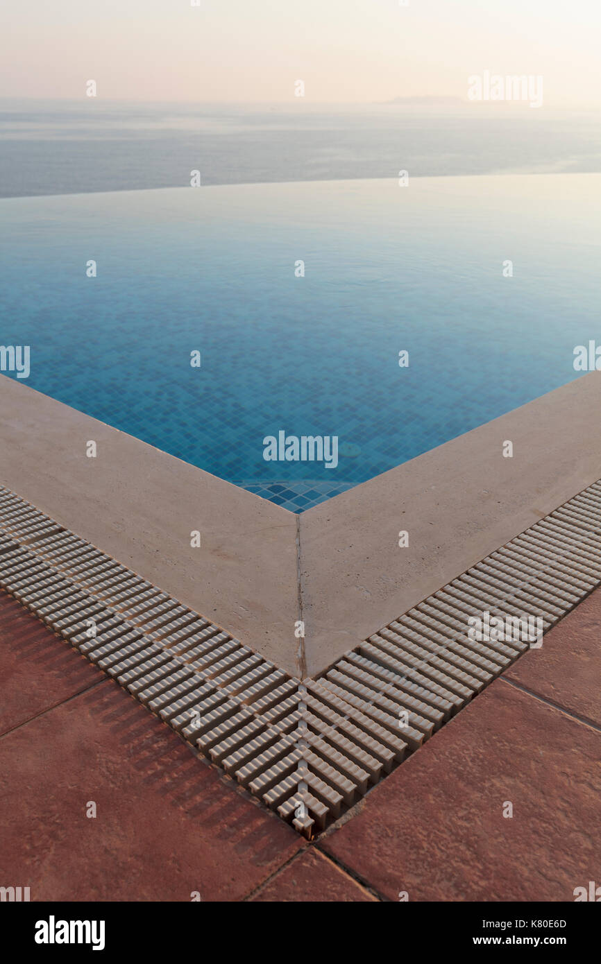 View into distance across infinity pool with lie lows and rings and sun ...