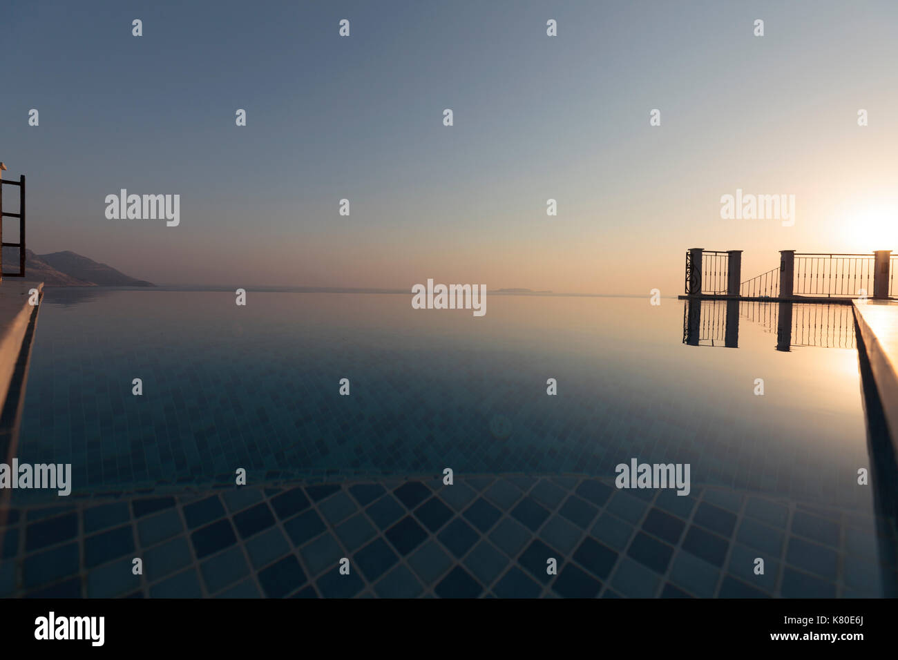 View into distance across infinity pool with lie lows and rings and sun ...