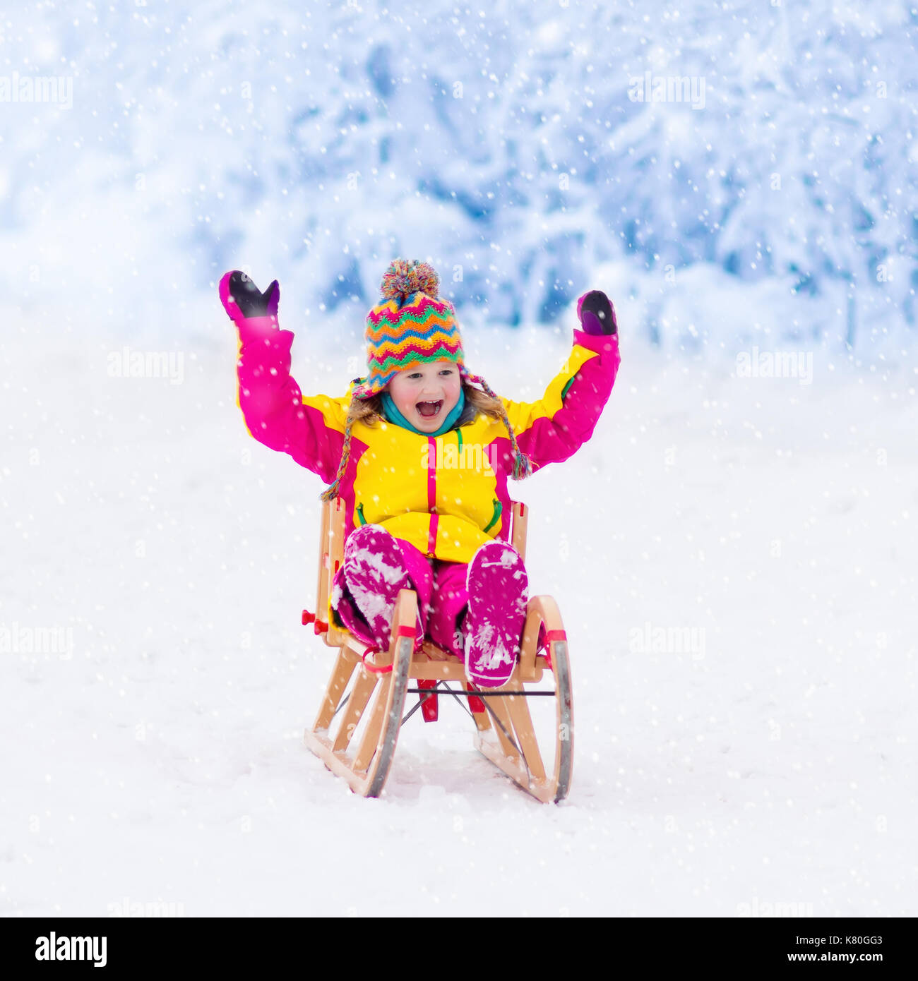 Little girl enjoying a sleigh ride. Child sledding. Toddler kid riding ...