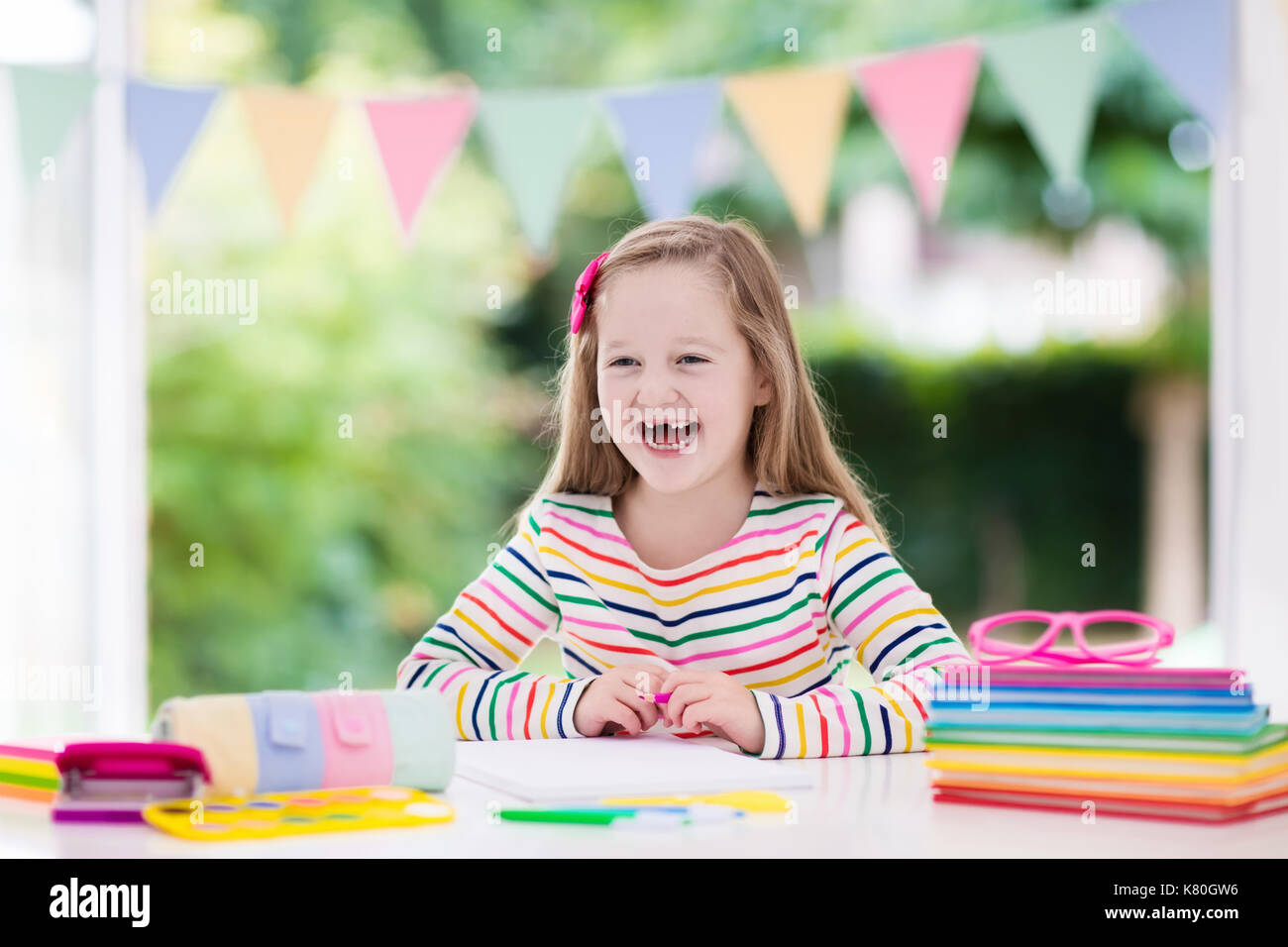 Child doing homework for school at white desk. Little girl with school ...