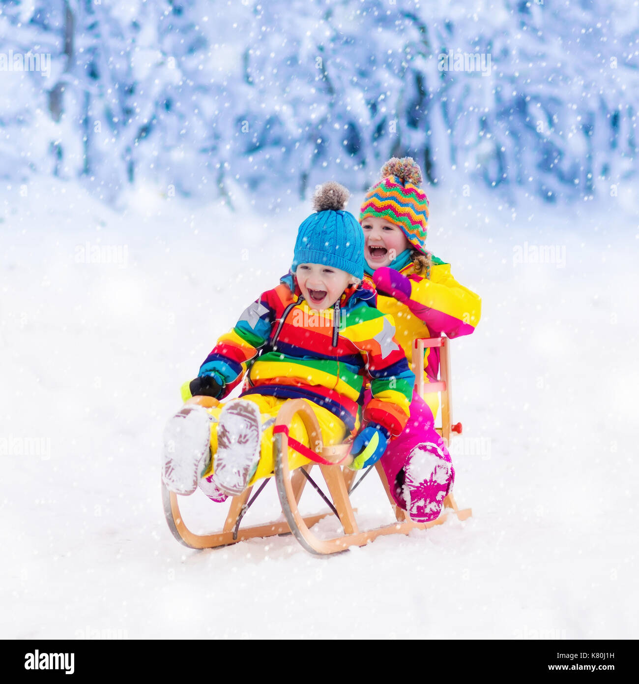 Little girl and boy enjoying sleigh ride. Child sledding. Toddler kid ...